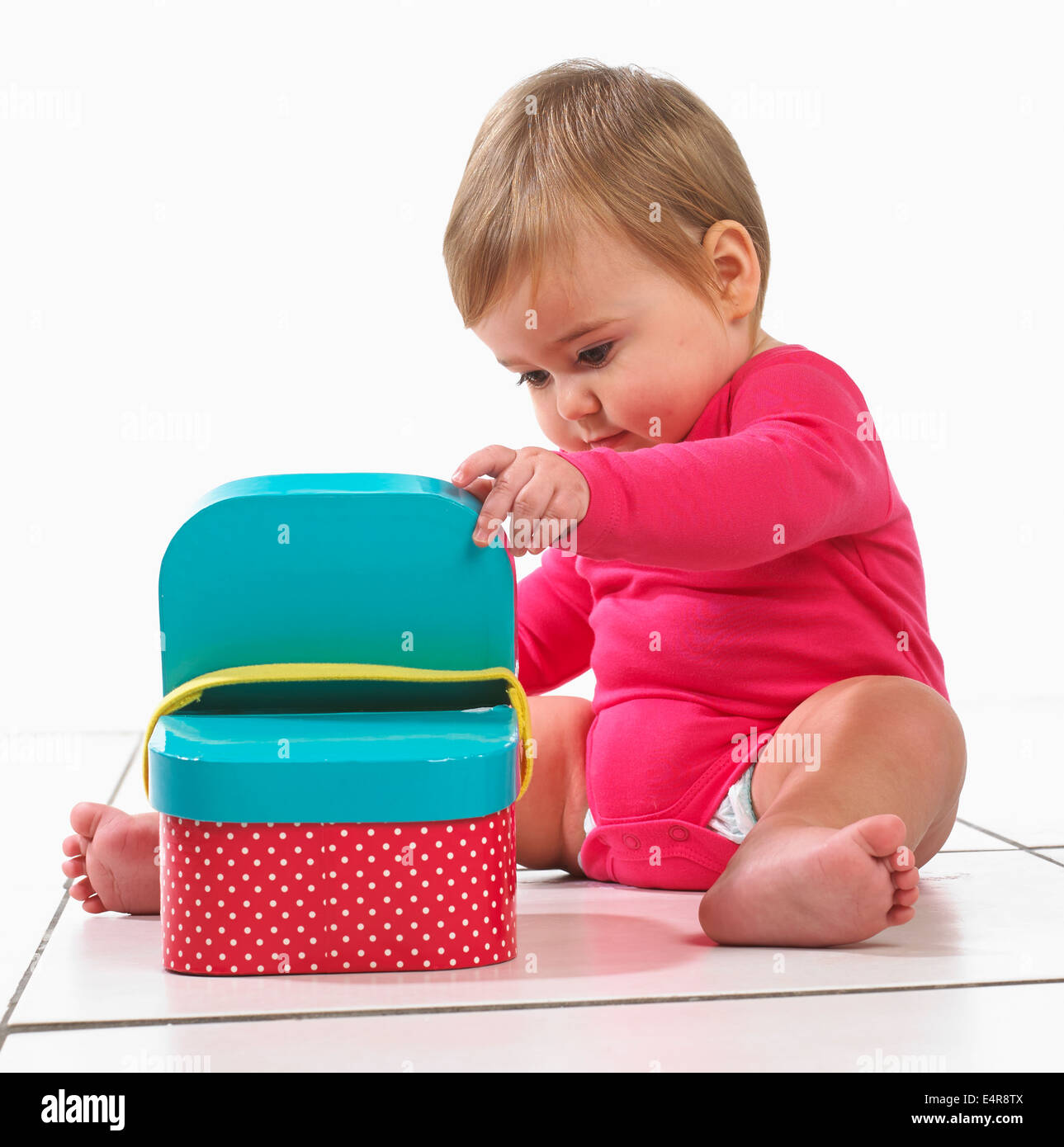 Baby girl (12 months) looking inside toy picnic basket Stock Photo - Alamy