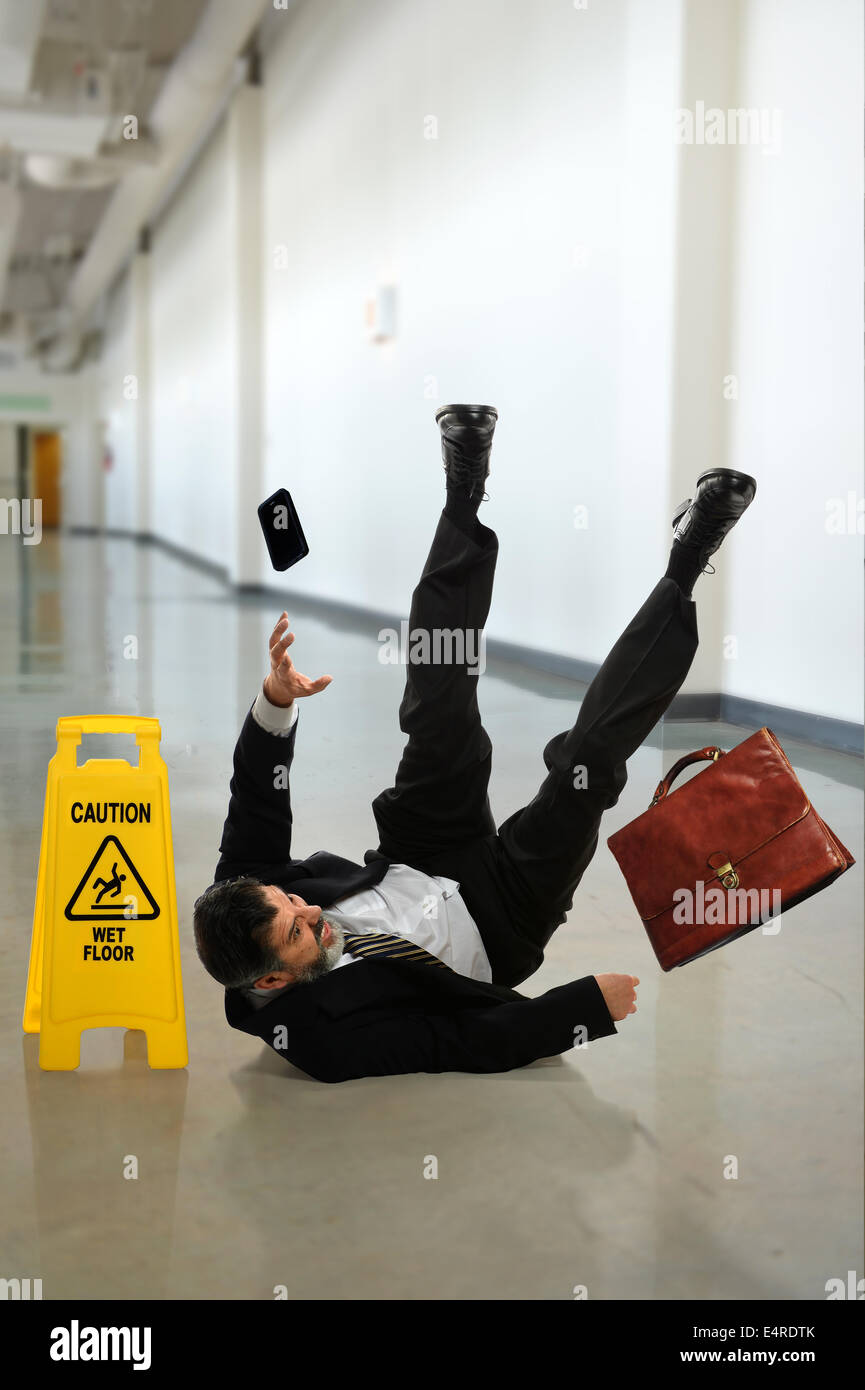 MAture businessman falling on wet floor inside building hallway Stock ...