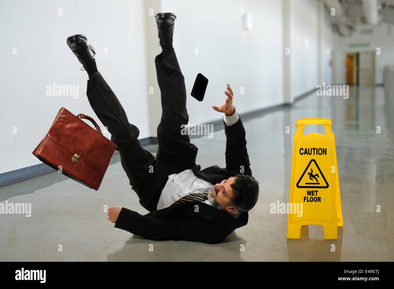 Senior businessman falling near caution sign in hallway Stock Photo - Alamy