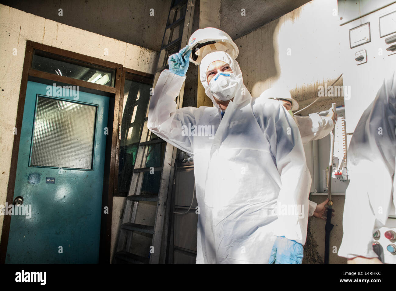 Workers at the fire damaged power plant cleaning up part of the fire ...