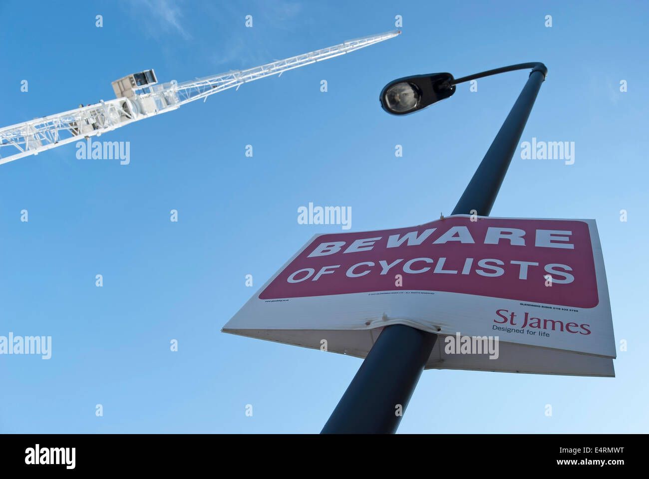 with crane in background, a beware of cyclists sign placed by the ...