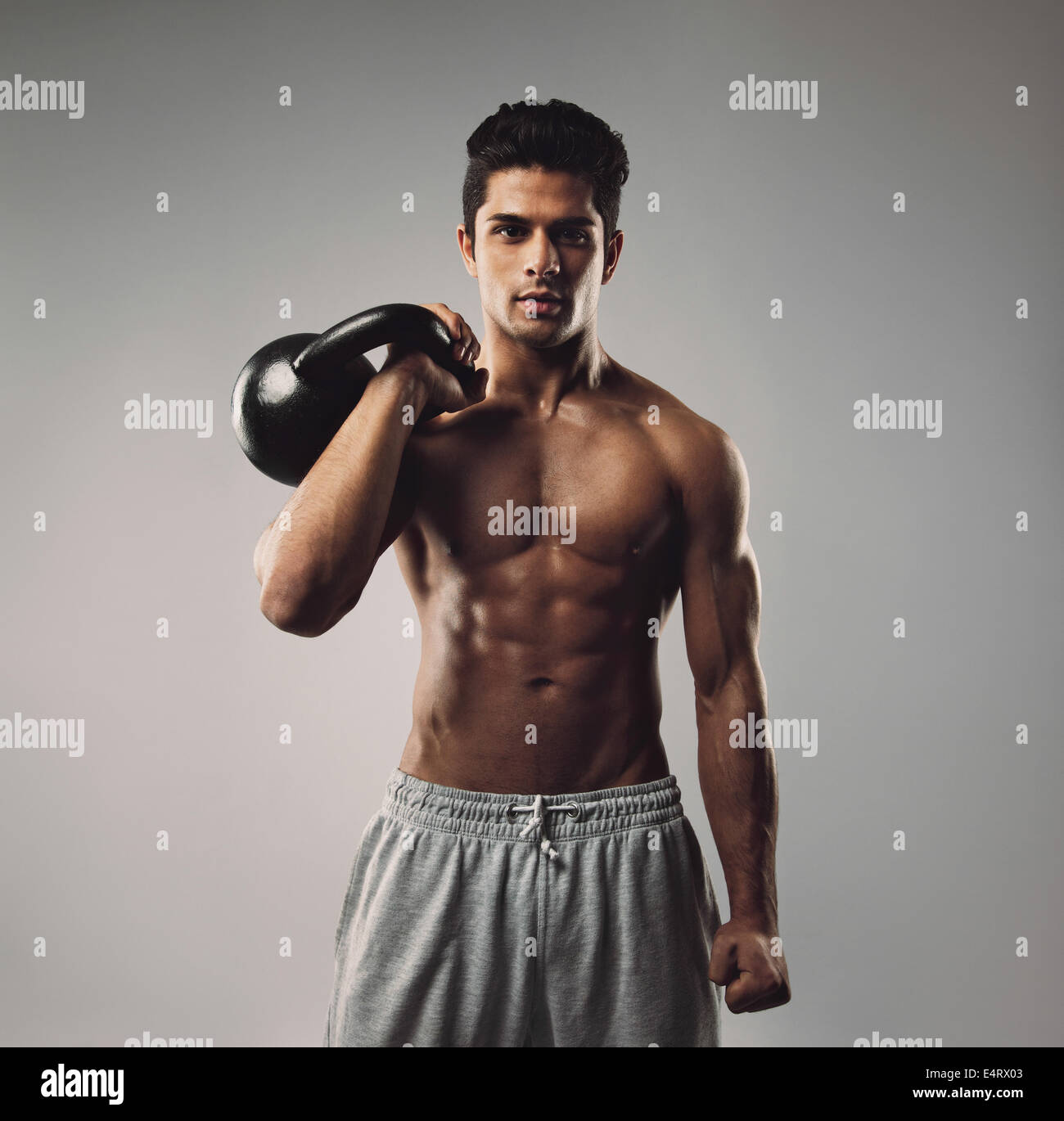 Portrait of strong young man working out with kettle bell. Young ...