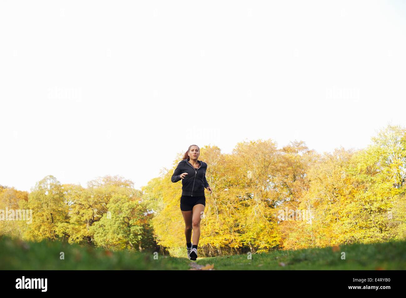 Image of fitness woman running in autumn park outdoors. Female athlete ...