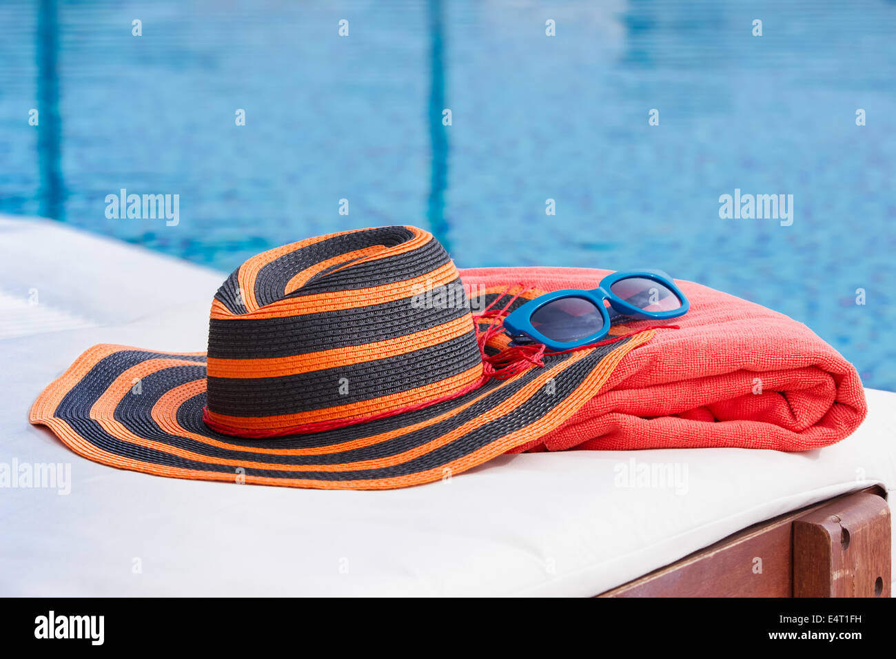 Sunbathing accessories on beach towel by a swimming pool Stock Photo ...