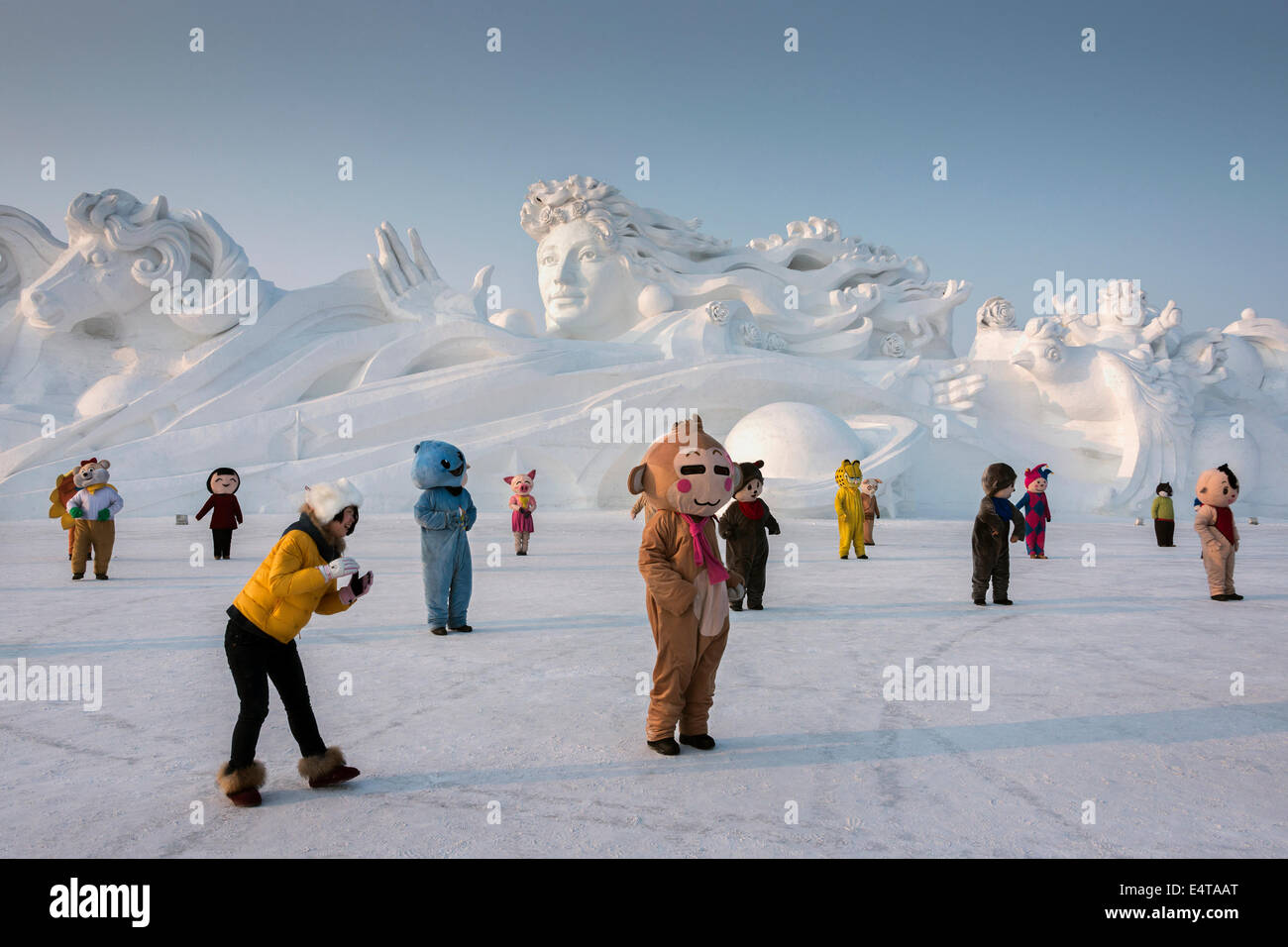 Cartoon figures dancing in front of a giant snow sculpture, Harbin Snow ...