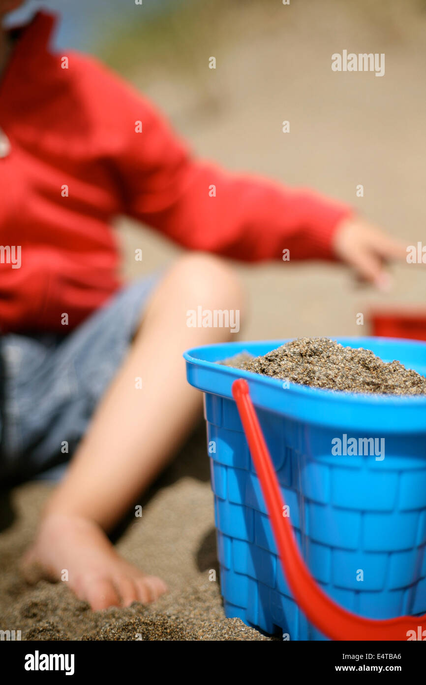 Boy making sandcastles with on beach with bucket and spade Stock Photo ...
