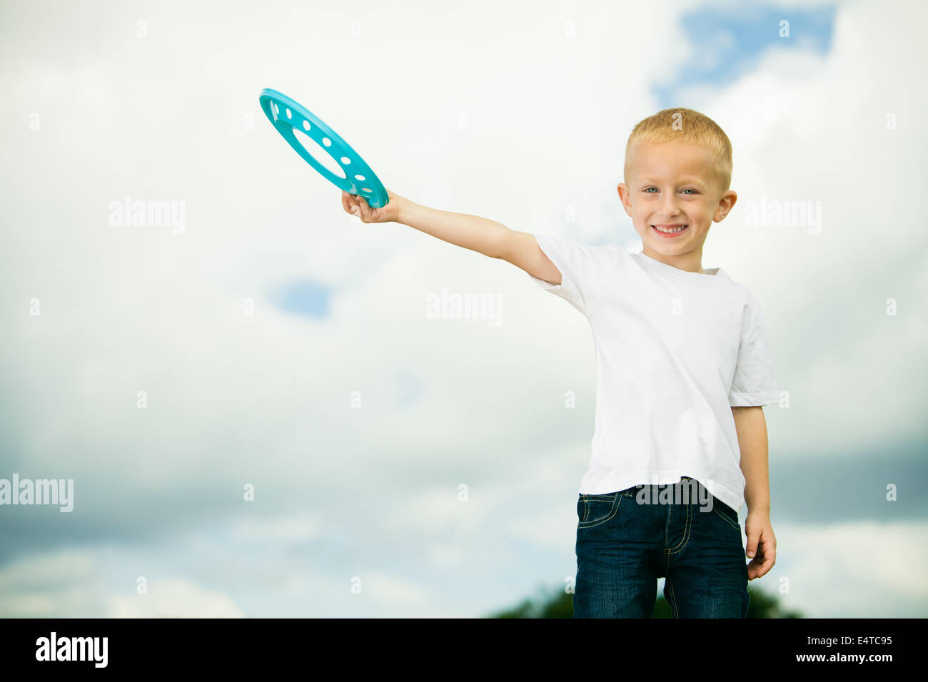 Happy smiling child in playground kid in action boy playing with blue ...