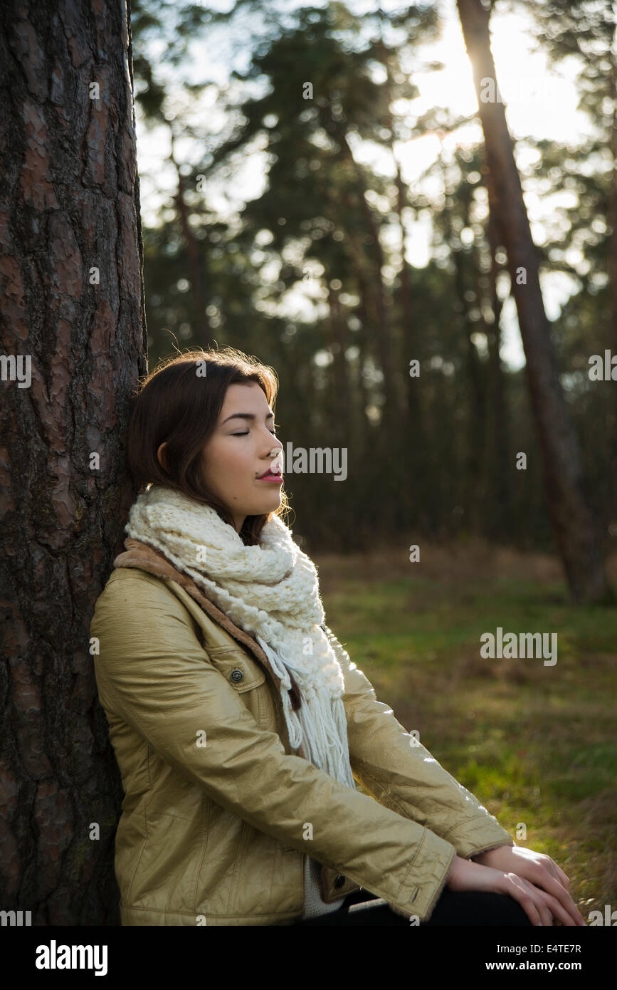 Young Woman Leaning against Tree Trunk, Mannheim, Baden-Wurttemberg ...