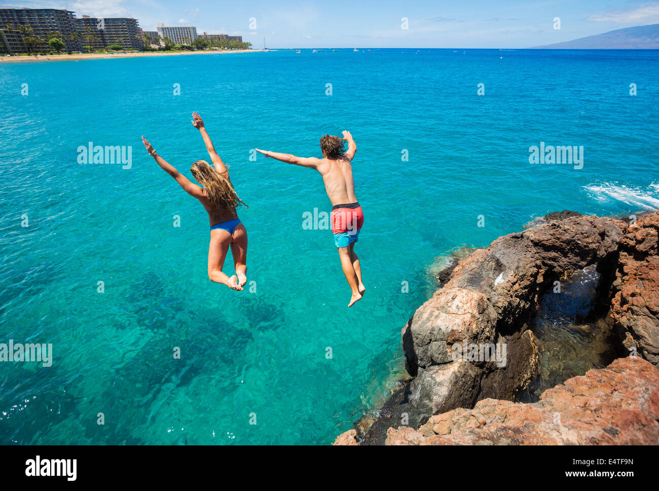 Summer fun, Friends cliff jumping into the ocean Stock Photo - Alamy