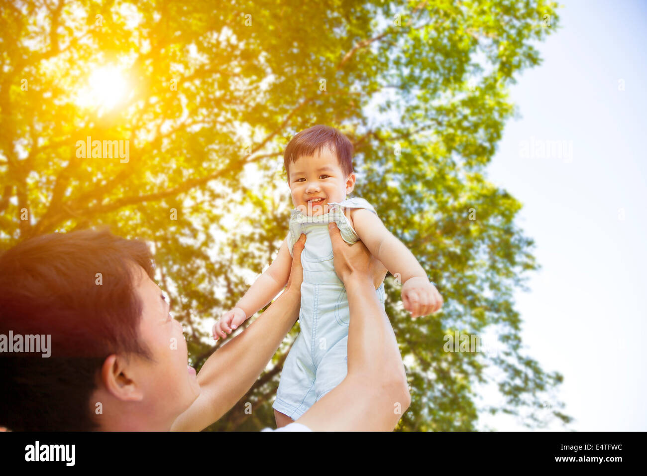 father raising his little smiling son up high Stock Photo - Alamy