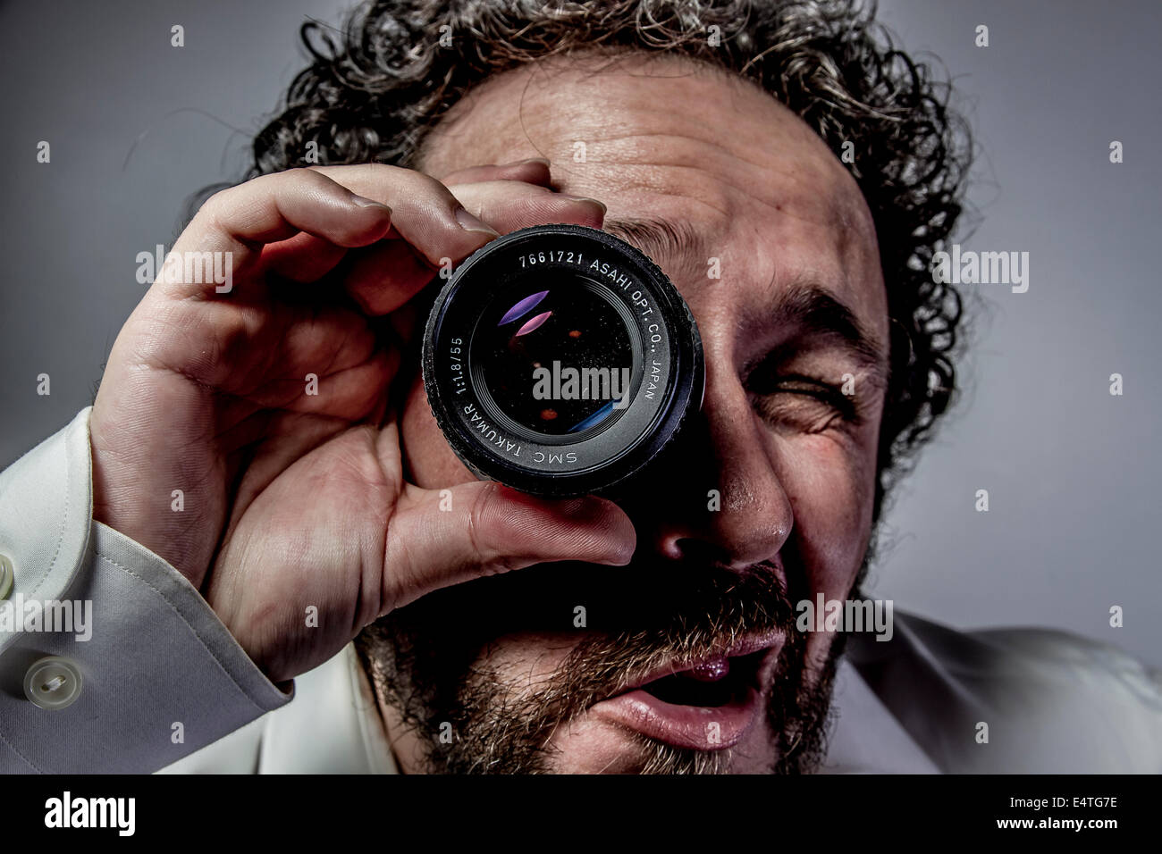photographer with lens, man with intense expression, white shirt Stock ...