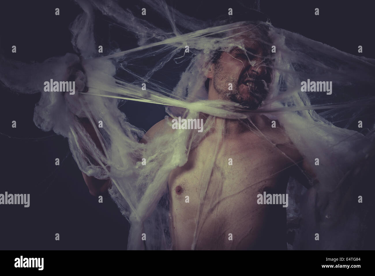 Danger, Man trapped in a spider web Stock Photo - Alamy