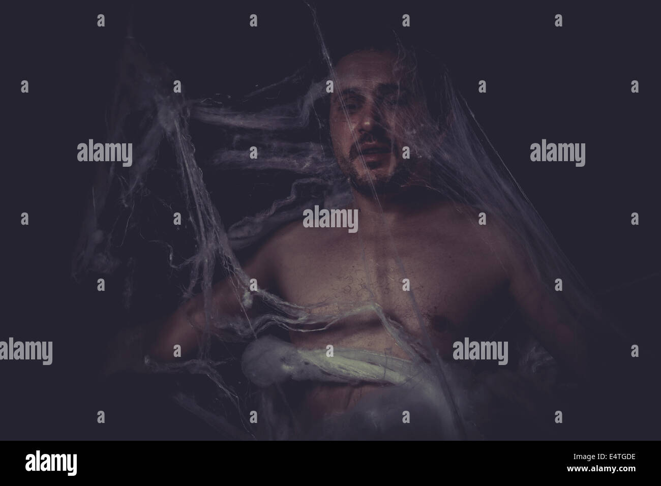 Horror, Man trapped in a spider web Stock Photo - Alamy