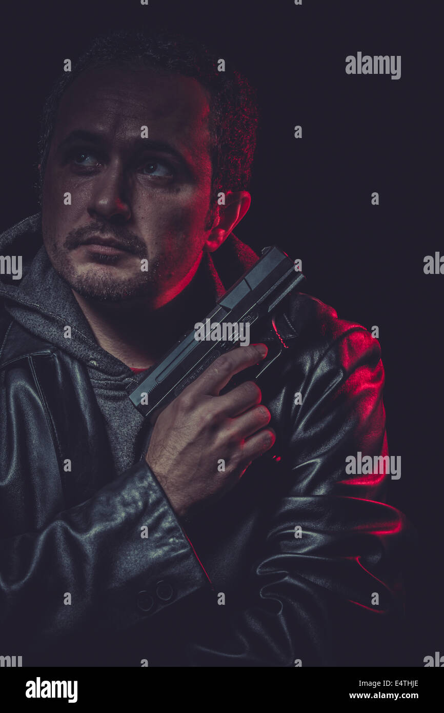 Assassin, man with black coat and gun Stock Photo - Alamy