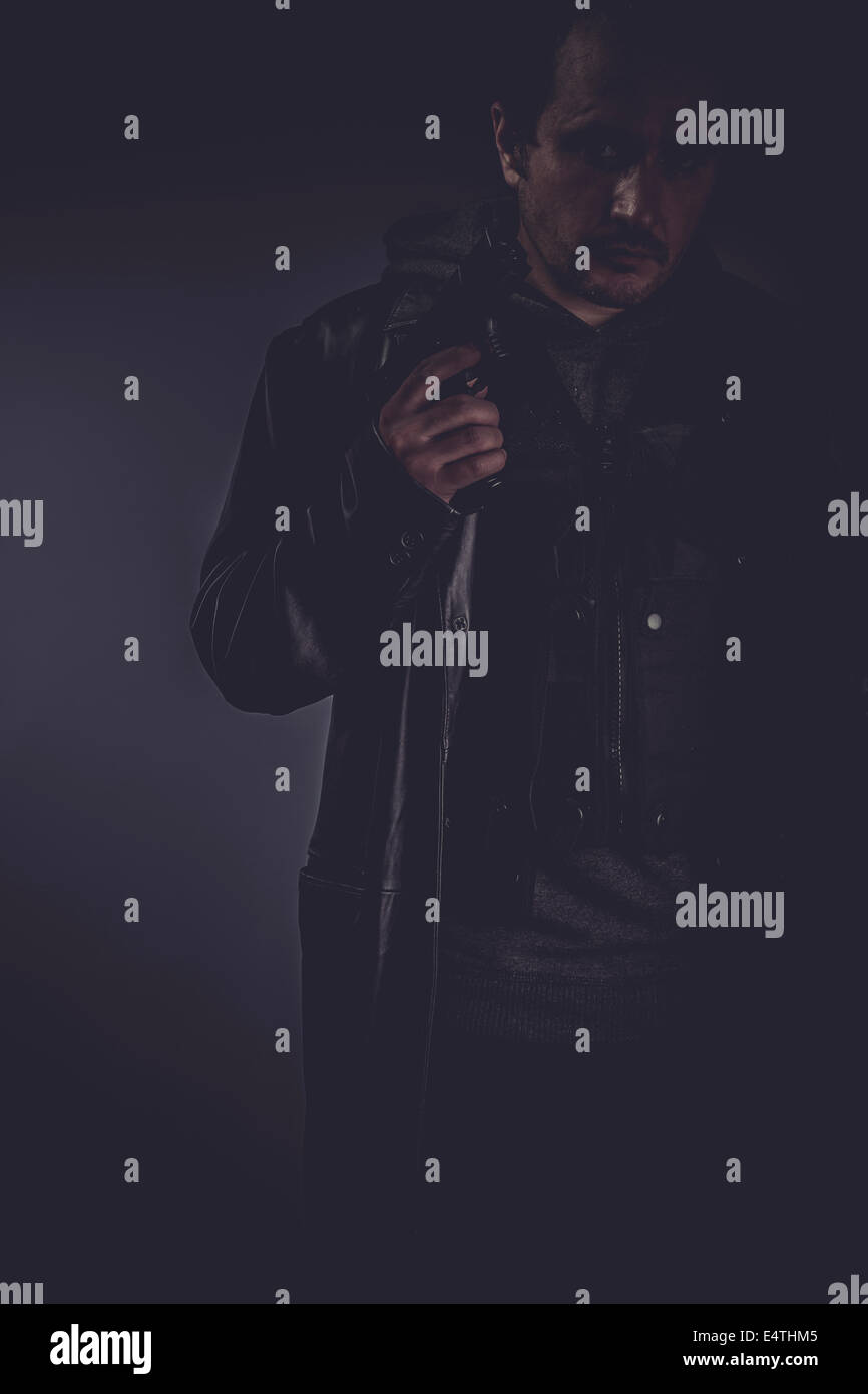 Bodyguard, portrait of stylish man with long leather jacket, gun armed ...