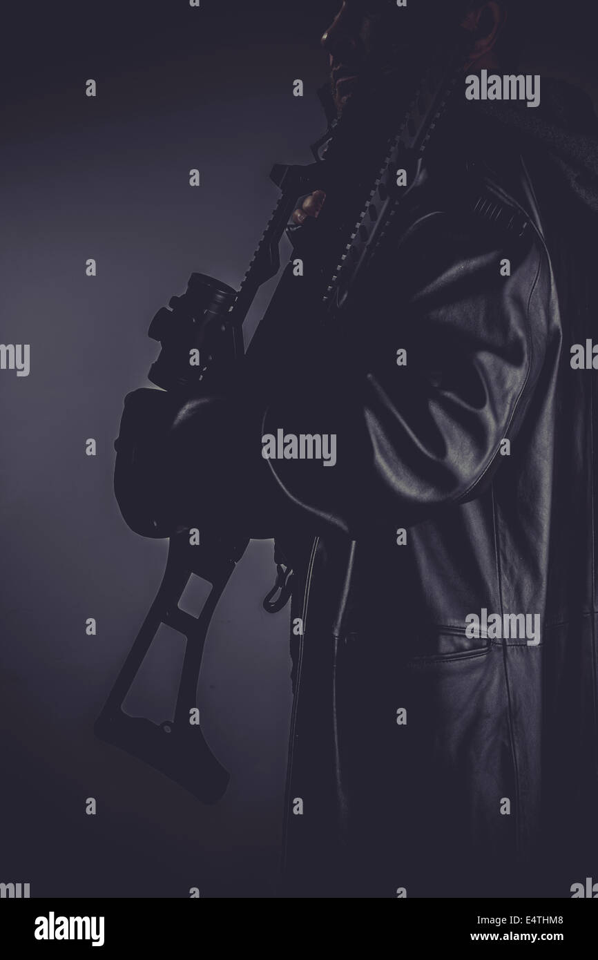 portrait of stylish man with long leather jacket, gun armed Stock Photo ...