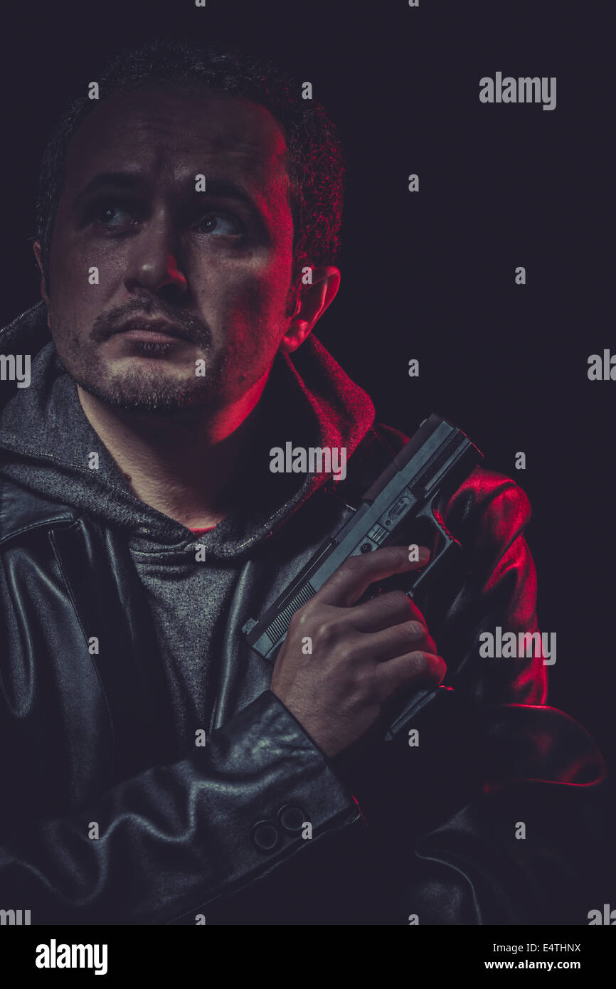 Assassin, man with black coat and gun Stock Photo - Alamy