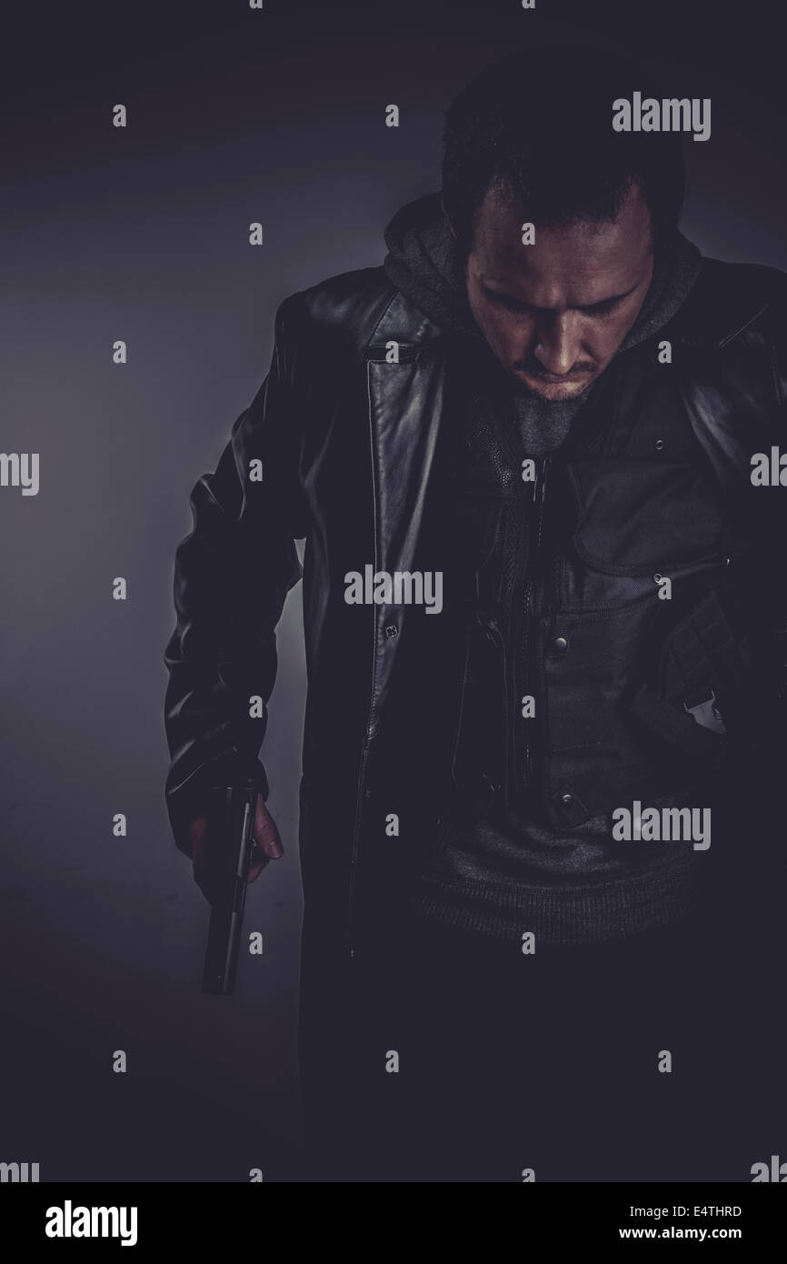 portrait of stylish man with long leather jacket, gun armed Stock Photo ...