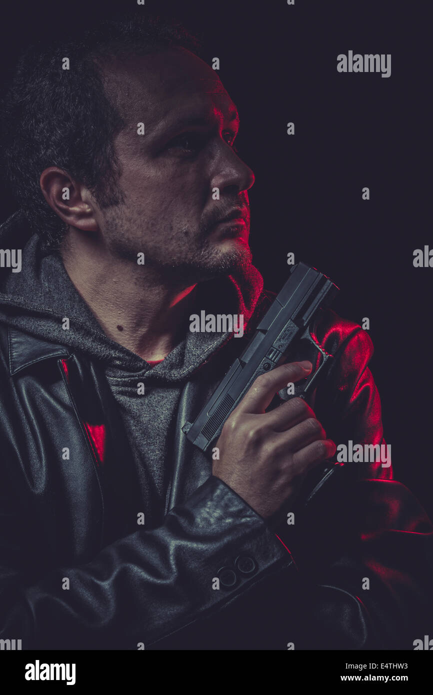Assassin, man with black coat and gun Stock Photo - Alamy