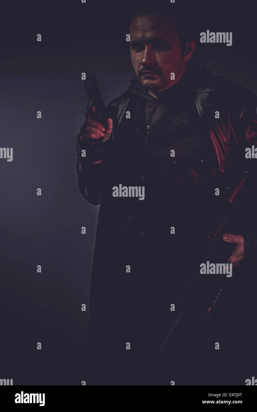 spy portrait of stylish man with long leather jacket, gun armed Stock ...