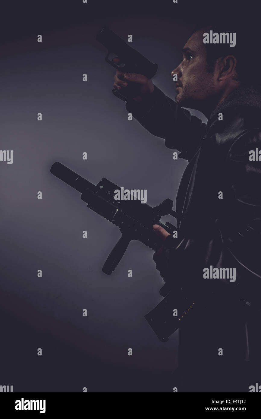 danger, portrait of stylish man with long leather jacket, gun armed ...