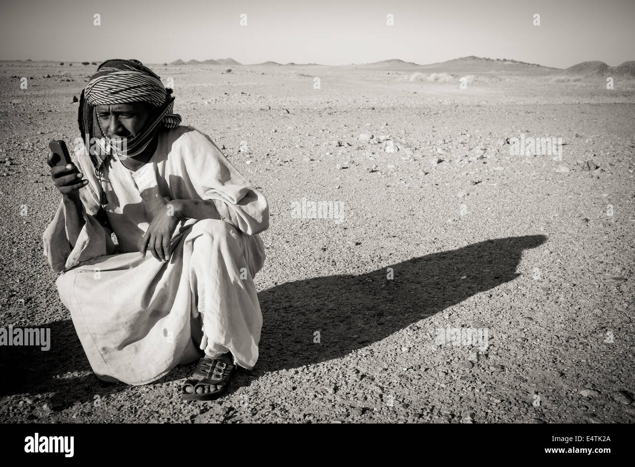 Sudanese nomad checking his mobile phone in the Sahara desert Stock ...