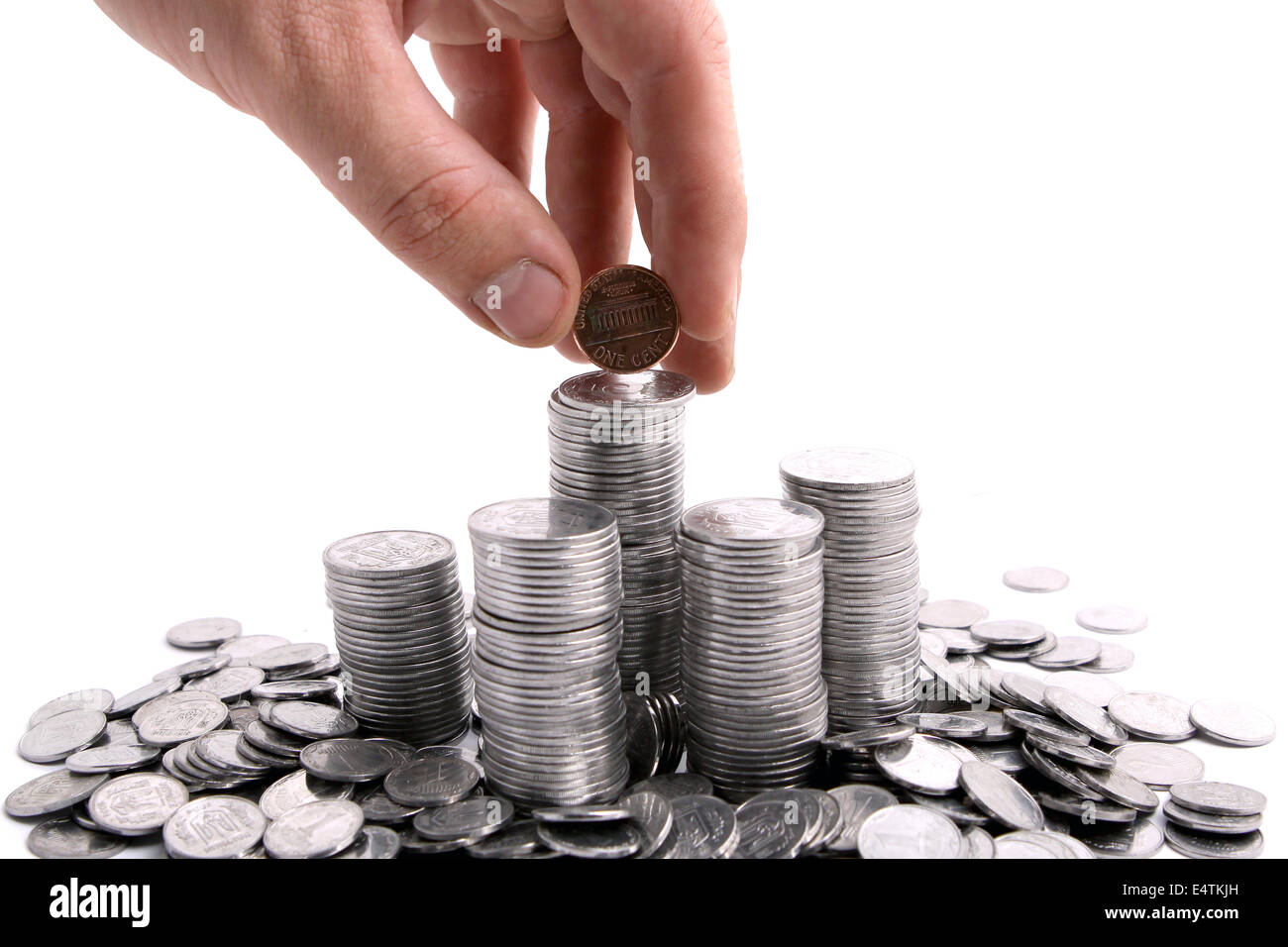 Hand adding coins against white background Stock Photo - Alamy