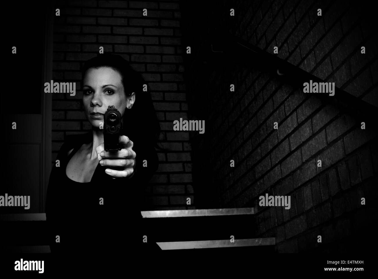 A female assassin with a gun pointed at you Stock Photo - Alamy