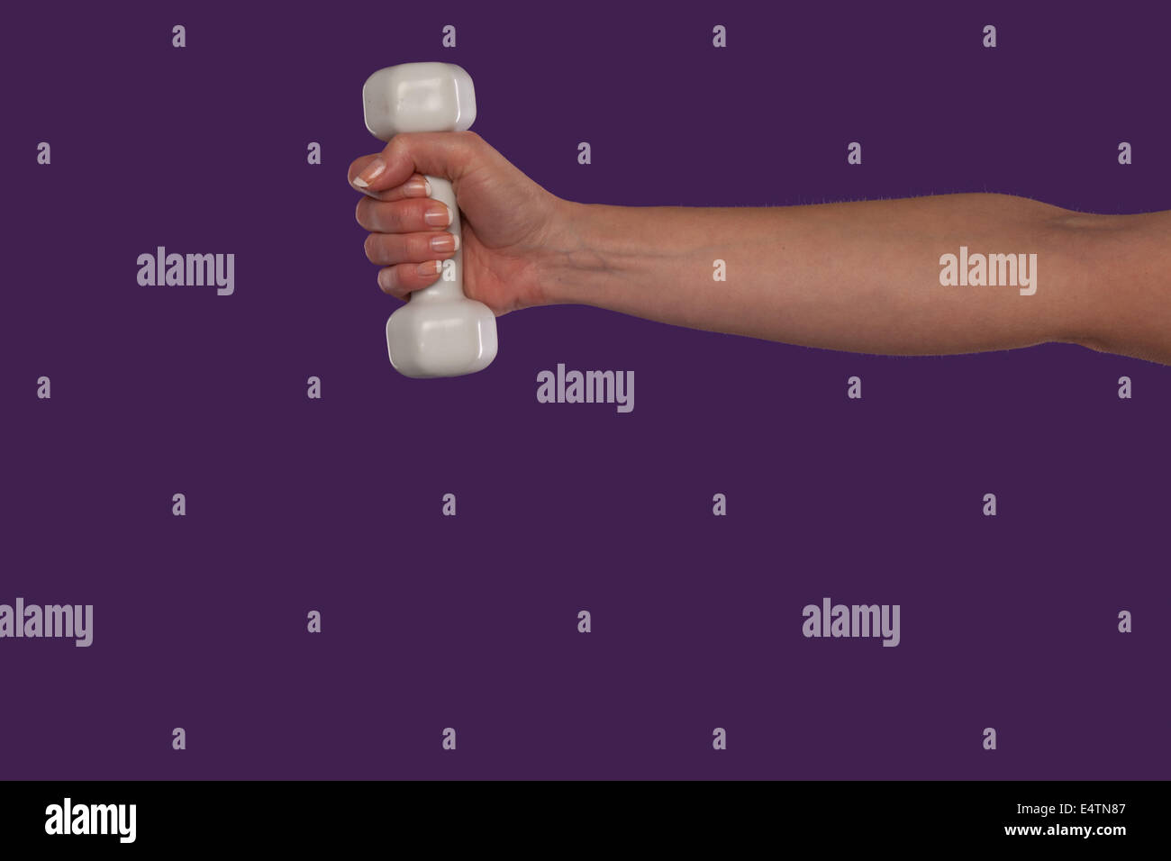 Female hand holding a small dumbbell Stock Photo - Alamy