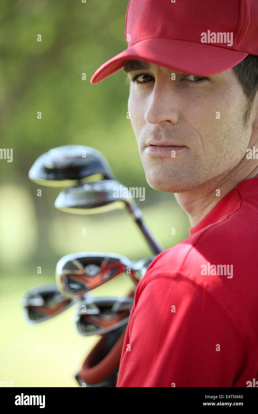 Golfer holding golf clubs Stock Photo - Alamy