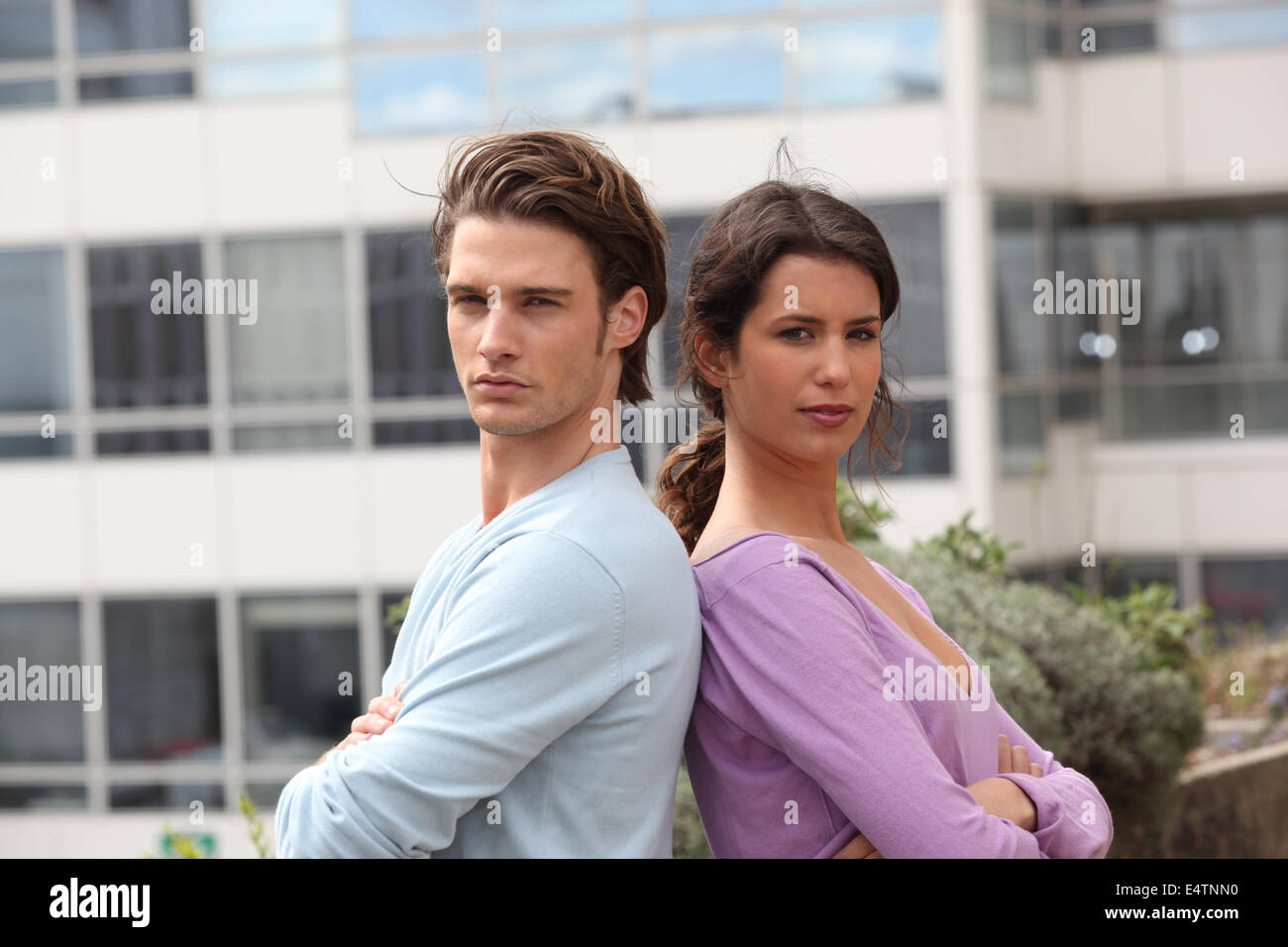 two young people standing back to back Stock Photo - Alamy