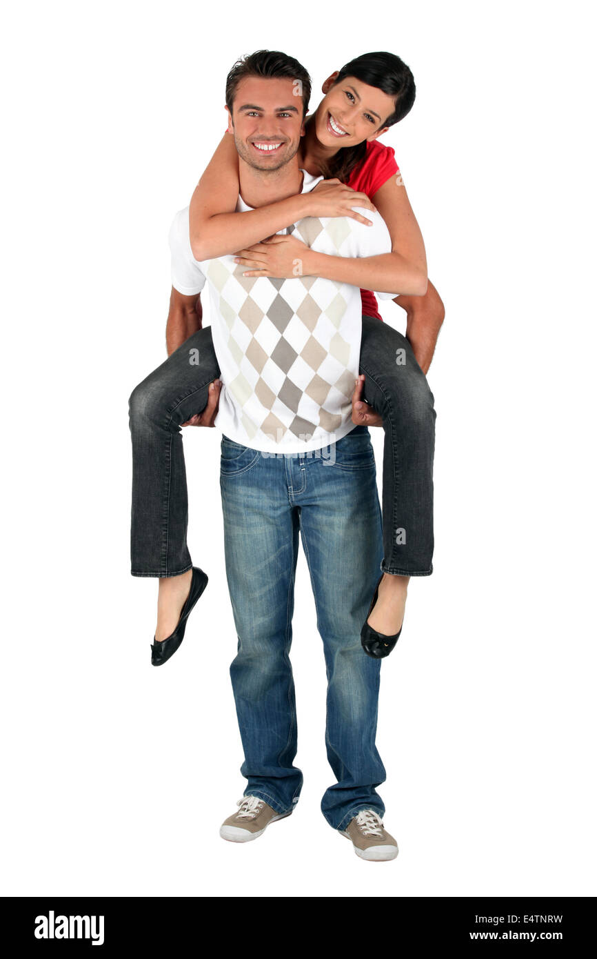 Man giving girlfriend piggy-back Stock Photo - Alamy