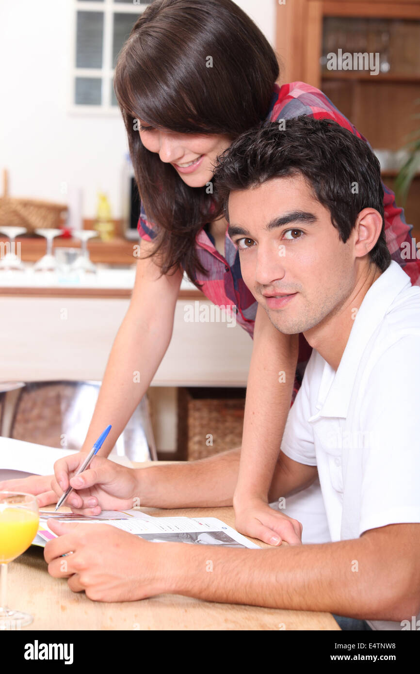 Couple writing on the kitchen table Stock Photo - Alamy
