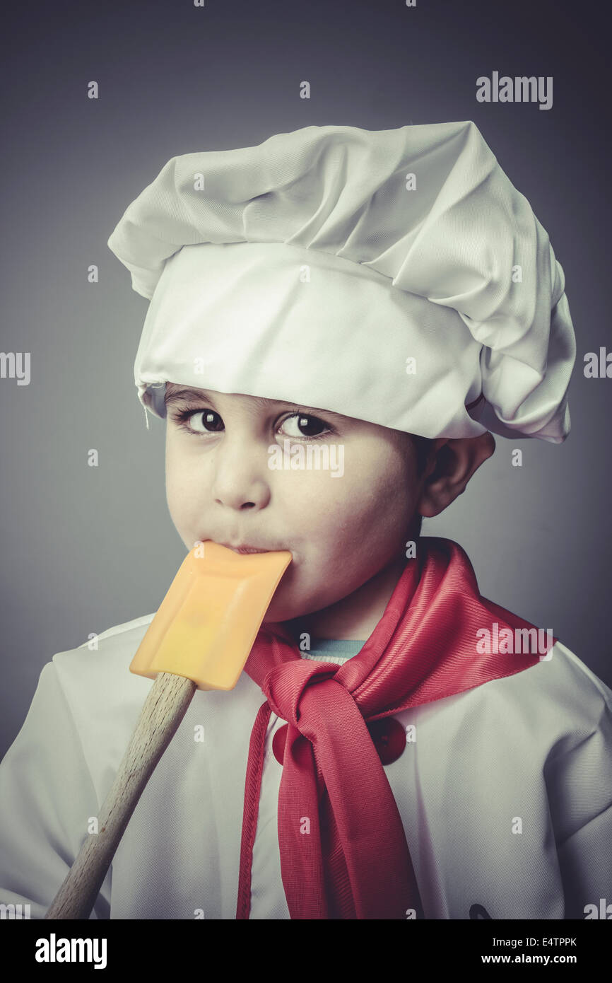 pretty boy dressed as a cook with kitchen utensils Stock Photo - Alamy
