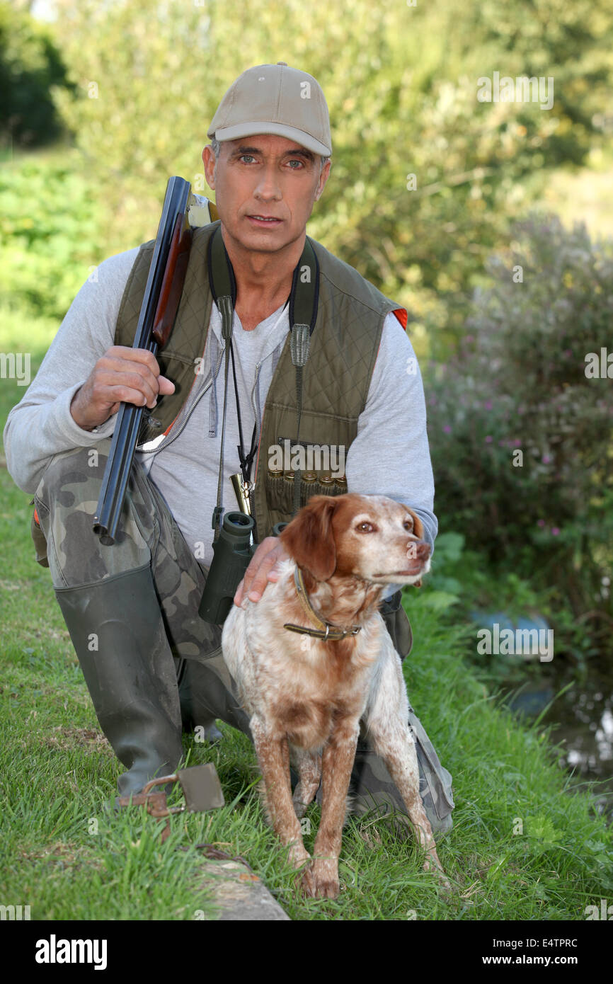 Hunter kneeling by dog Stock Photo - Alamy