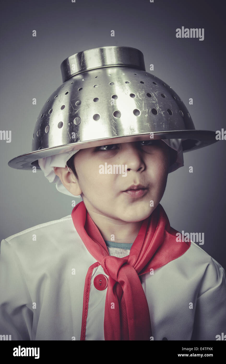 expression boy dressed as a cook with kitchen utensils Stock Photo - Alamy