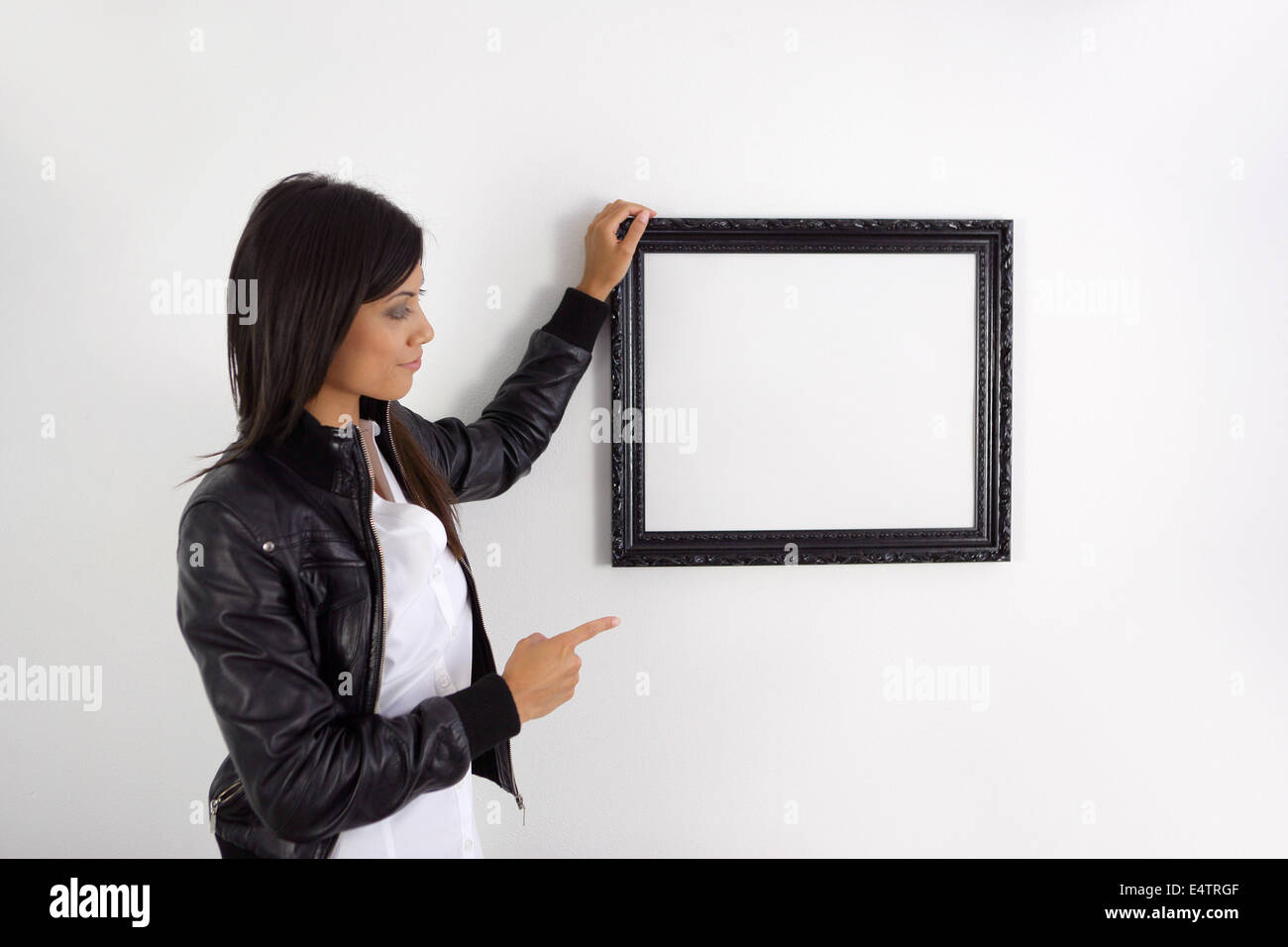 Woman pointing to a picture frame Stock Photo - Alamy