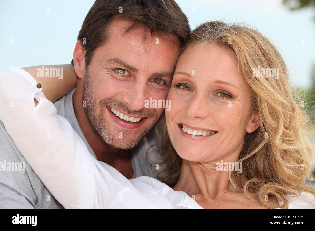 Couple stood with arms around each other Stock Photo - Alamy