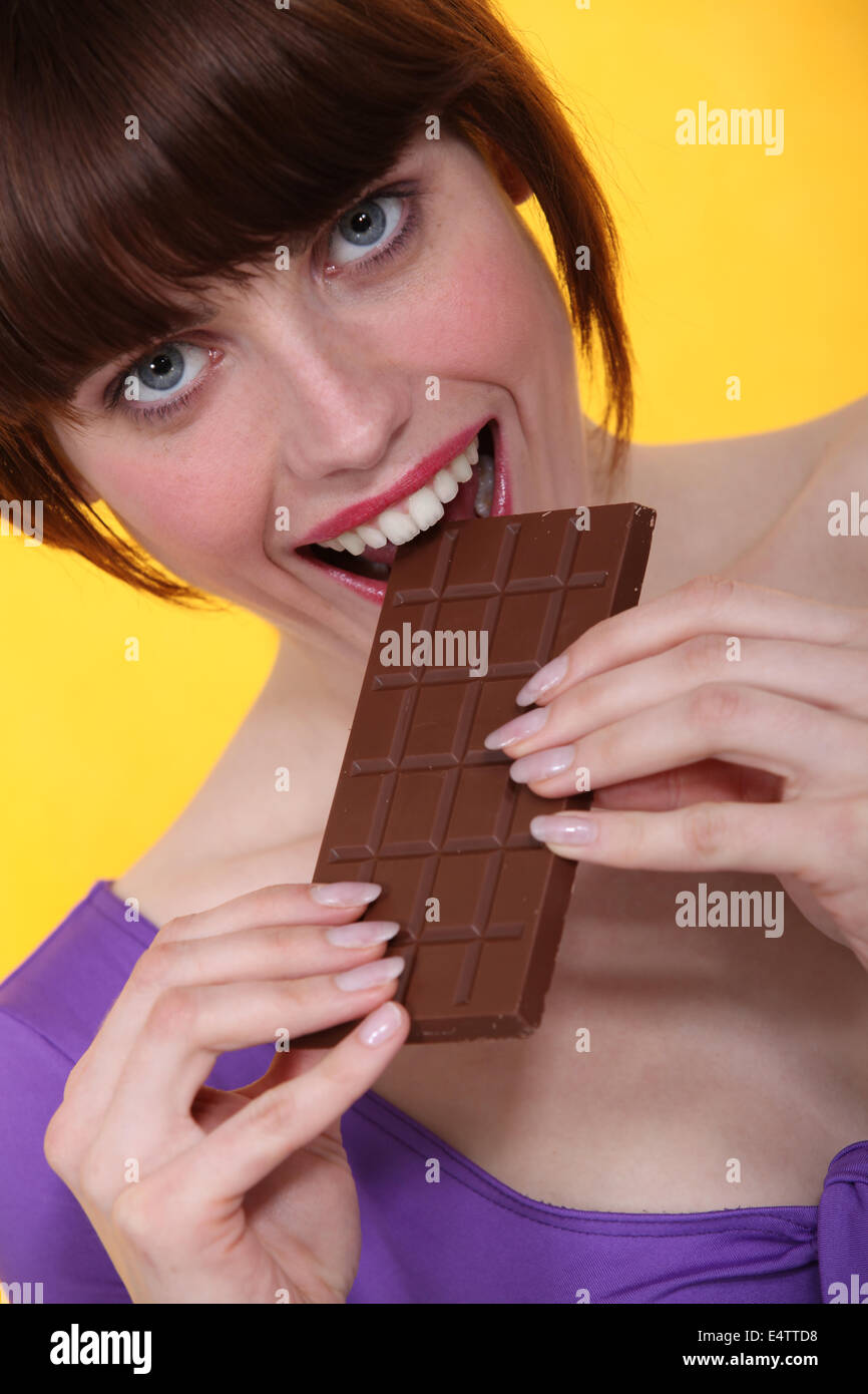 Woman eating chocolate bar Stock Photo - Alamy