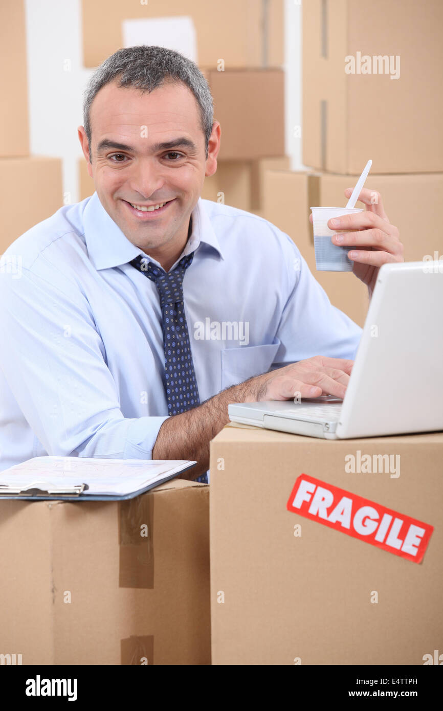 man amid cardboard boxes Stock Photo - Alamy