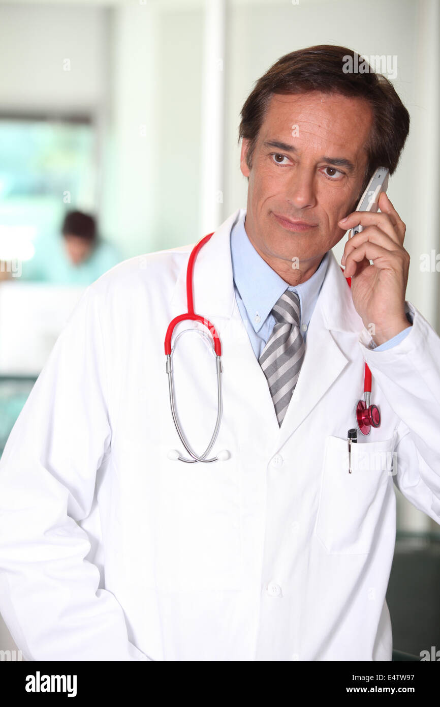 Hospital doctor using a cellphone Stock Photo - Alamy