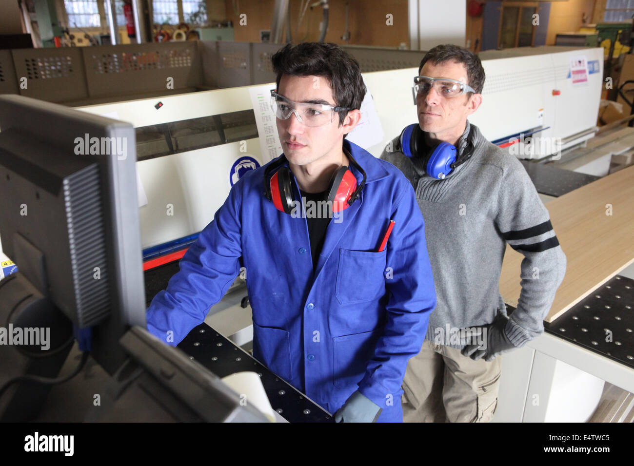 Young intern operating factory saw Stock Photo - Alamy