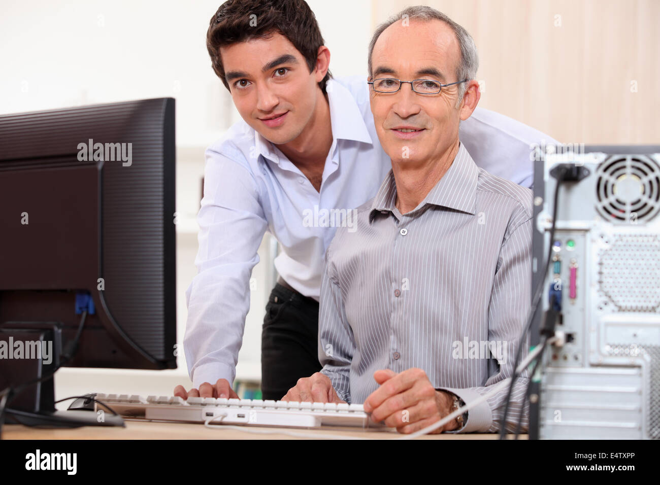 Man helping granddad with computer Stock Photo - Alamy