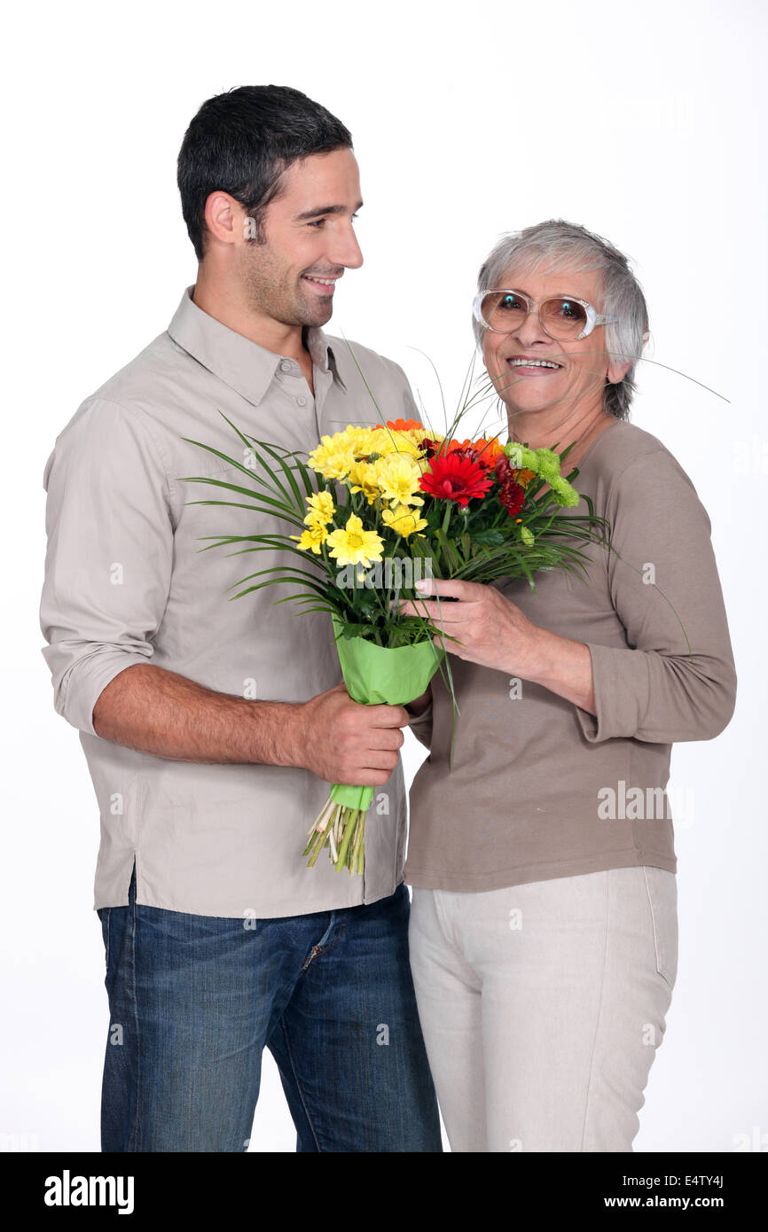 Son giving mother flowers Stock Photo - Alamy