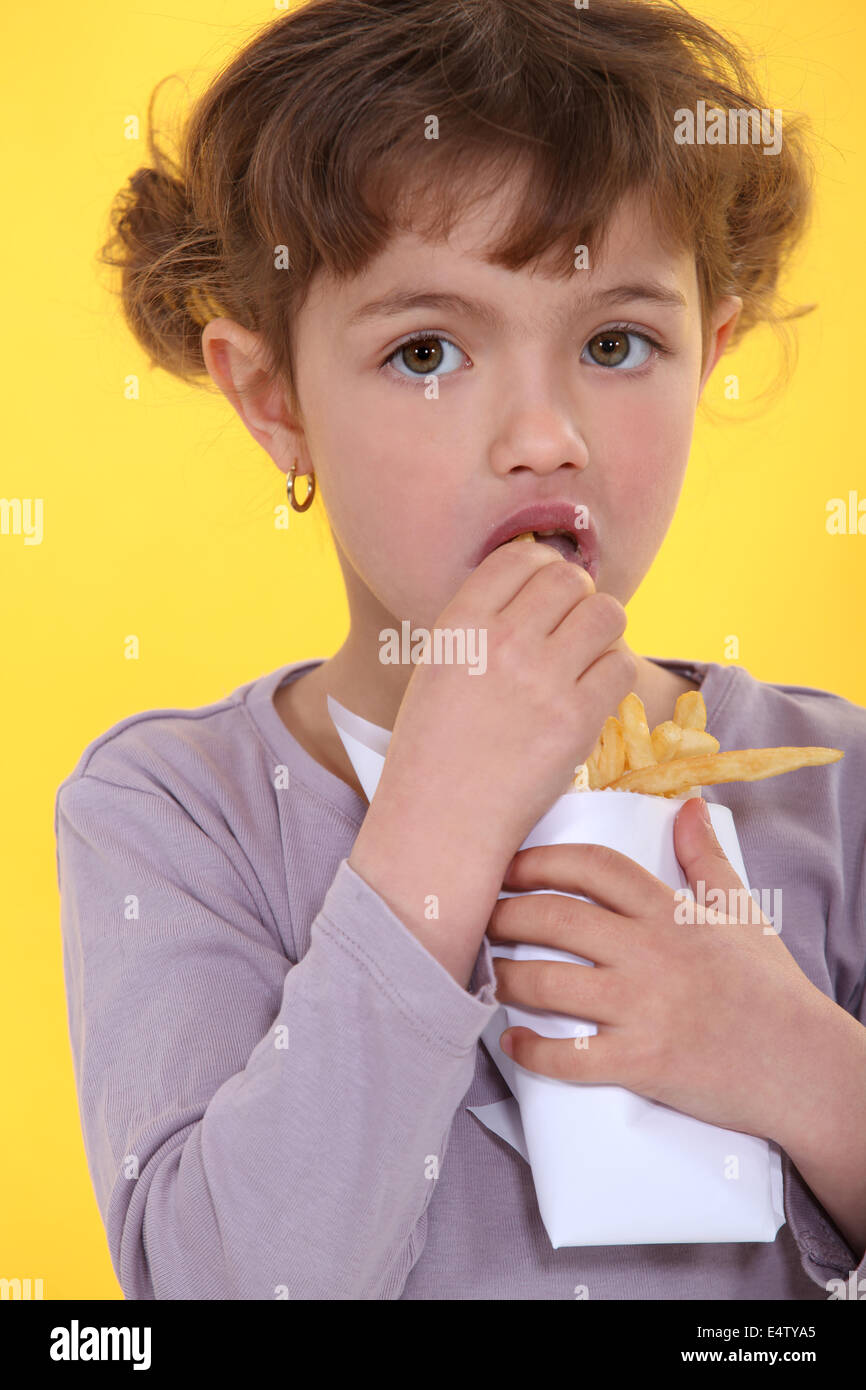 Young girl eating fries Stock Photo - Alamy