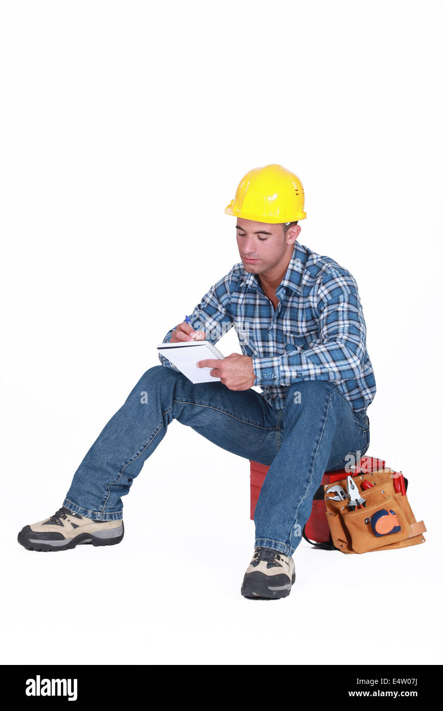 Construction worker writing in a notebook Stock Photo - Alamy
