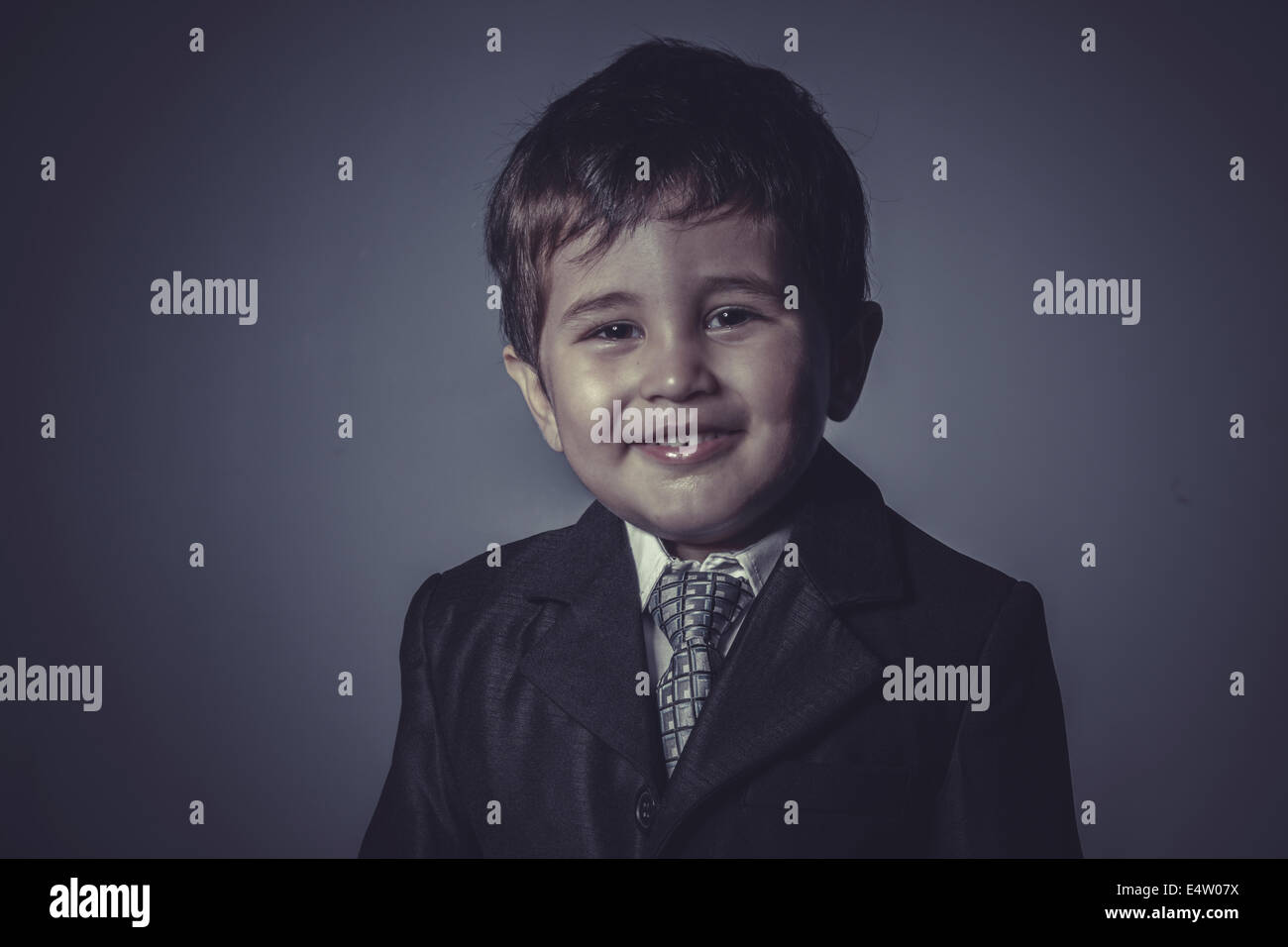 happy little business boy over grey background Stock Photo - Alamy