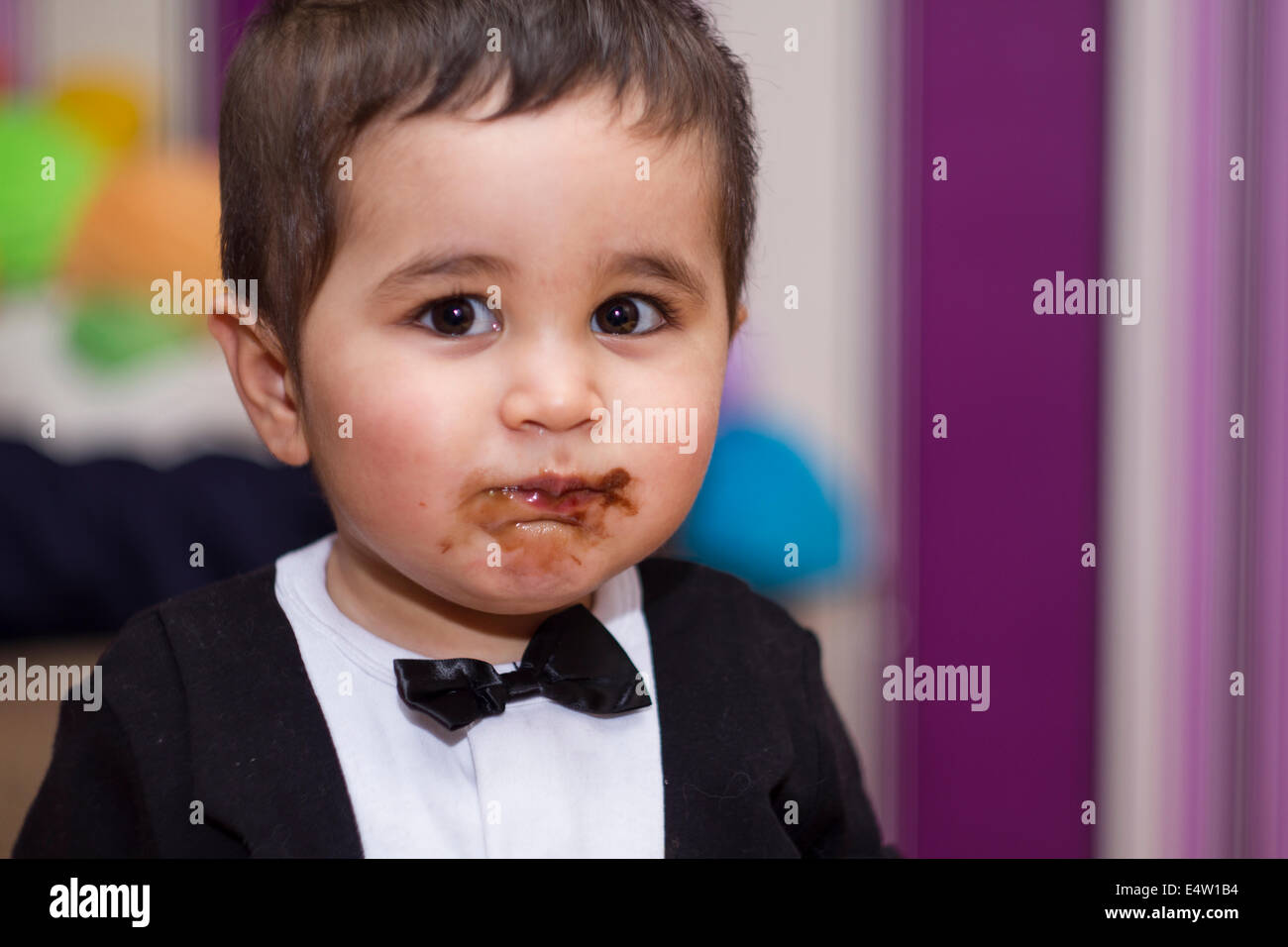 Happy, Adorable happy baby eating chocolate, wearing suit and bow tie ...