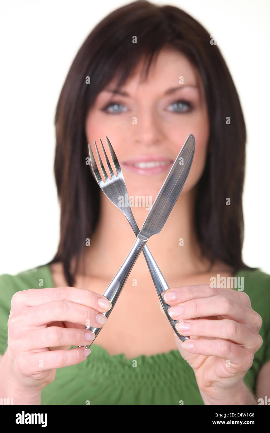 Woman showing knife and fork Stock Photo - Alamy