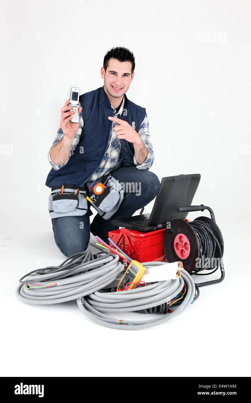 Electrican pointing to his mobile phone Stock Photo - Alamy